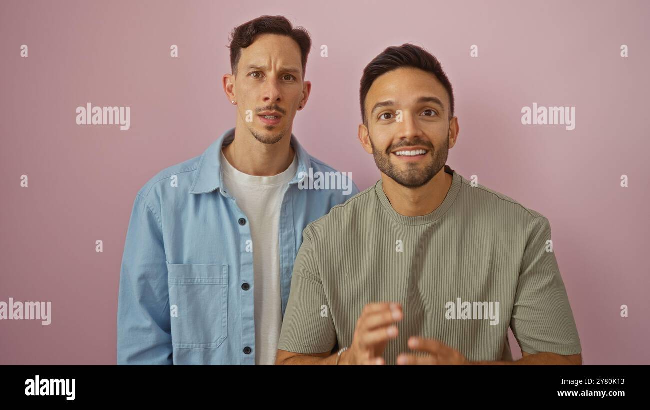 Two men in love standing together against an isolated pink background ...