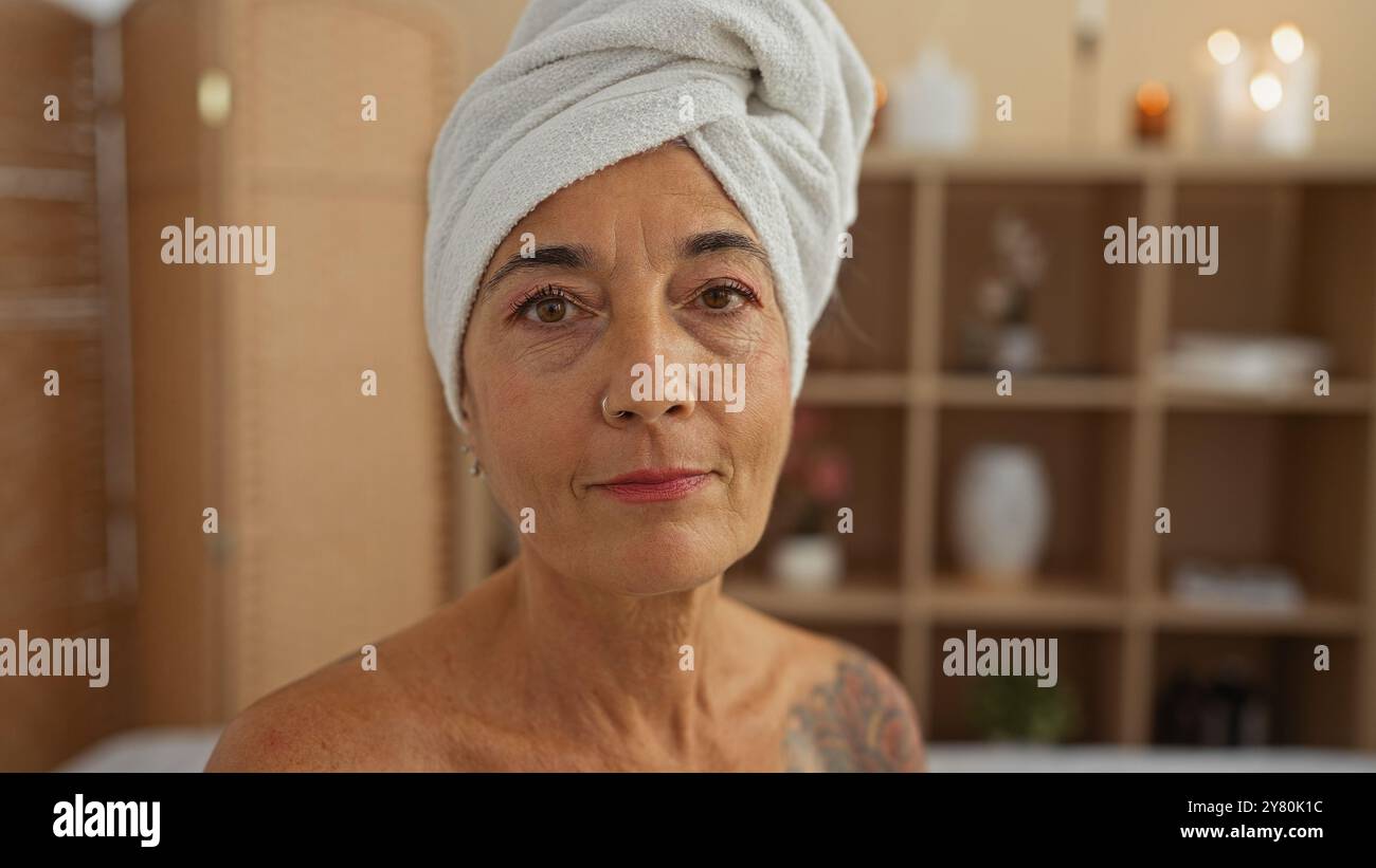 Mature woman with towel wrapped on head relaxing in spa wellness center ...