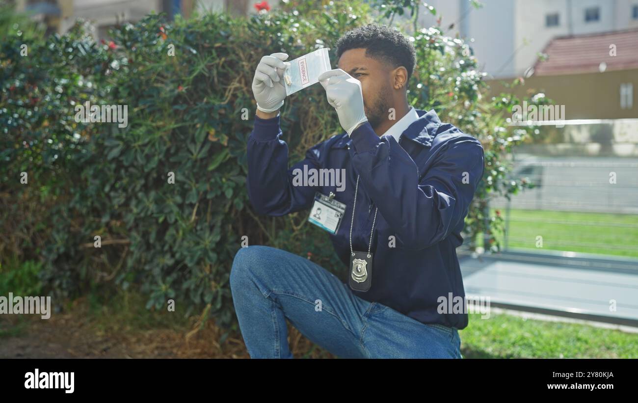 African american police officer examining evidence outdoors in a garden ...
