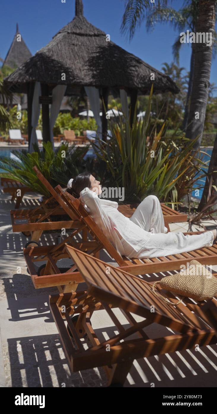 A relaxed woman enjoys sunshine at a luxury bali resort, embodying ...