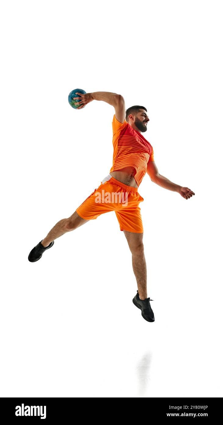 Powerful determined man, handball athlete in orange uniform in motion ...