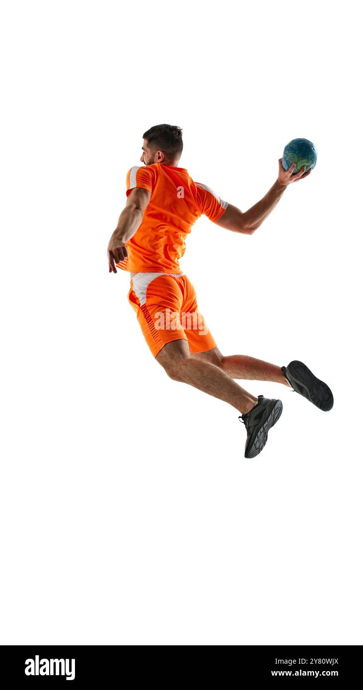 Powerful determined man, handball athlete in orange uniform in motion ...