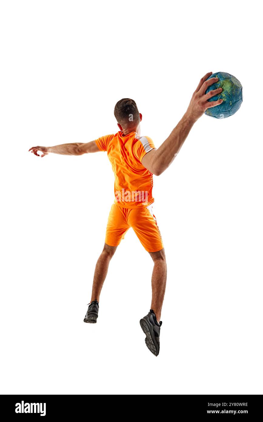 Young athletic woman, handball player in orange uniform in motion ...
