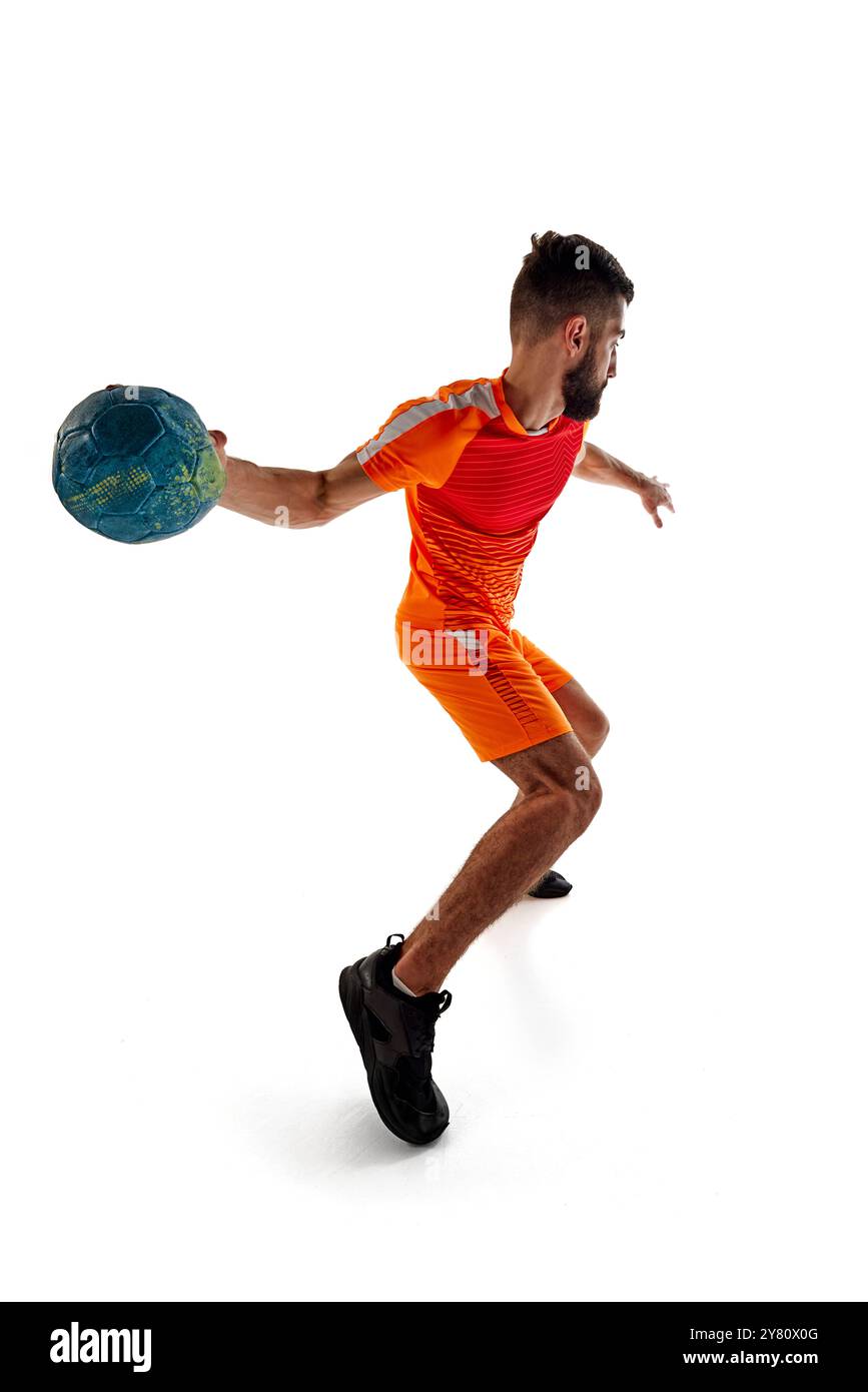 Dynamic image of young bearded man in orange uniform, handball player ...