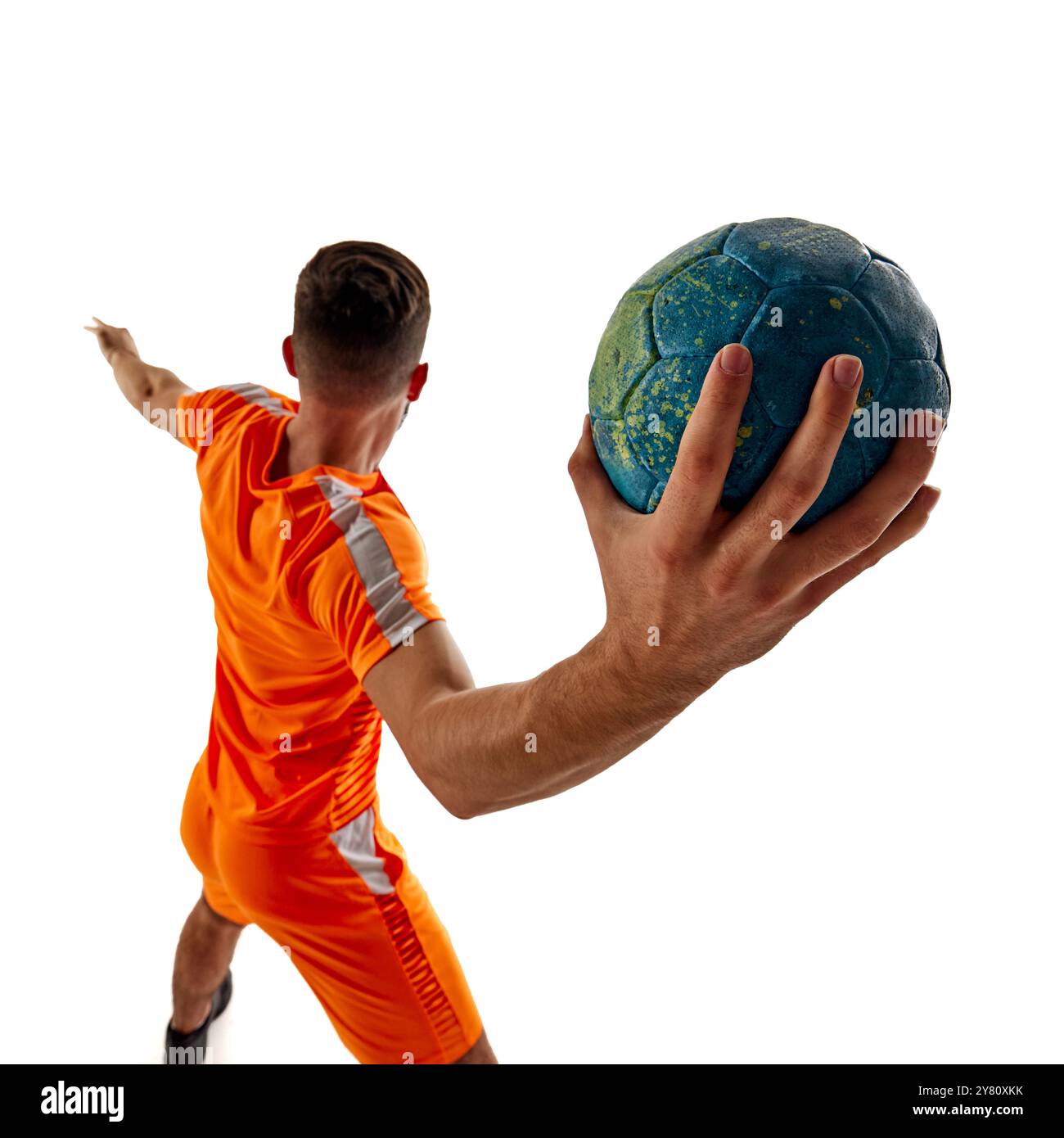 Competitive and focused man in orange uniform, handball player throwing ...