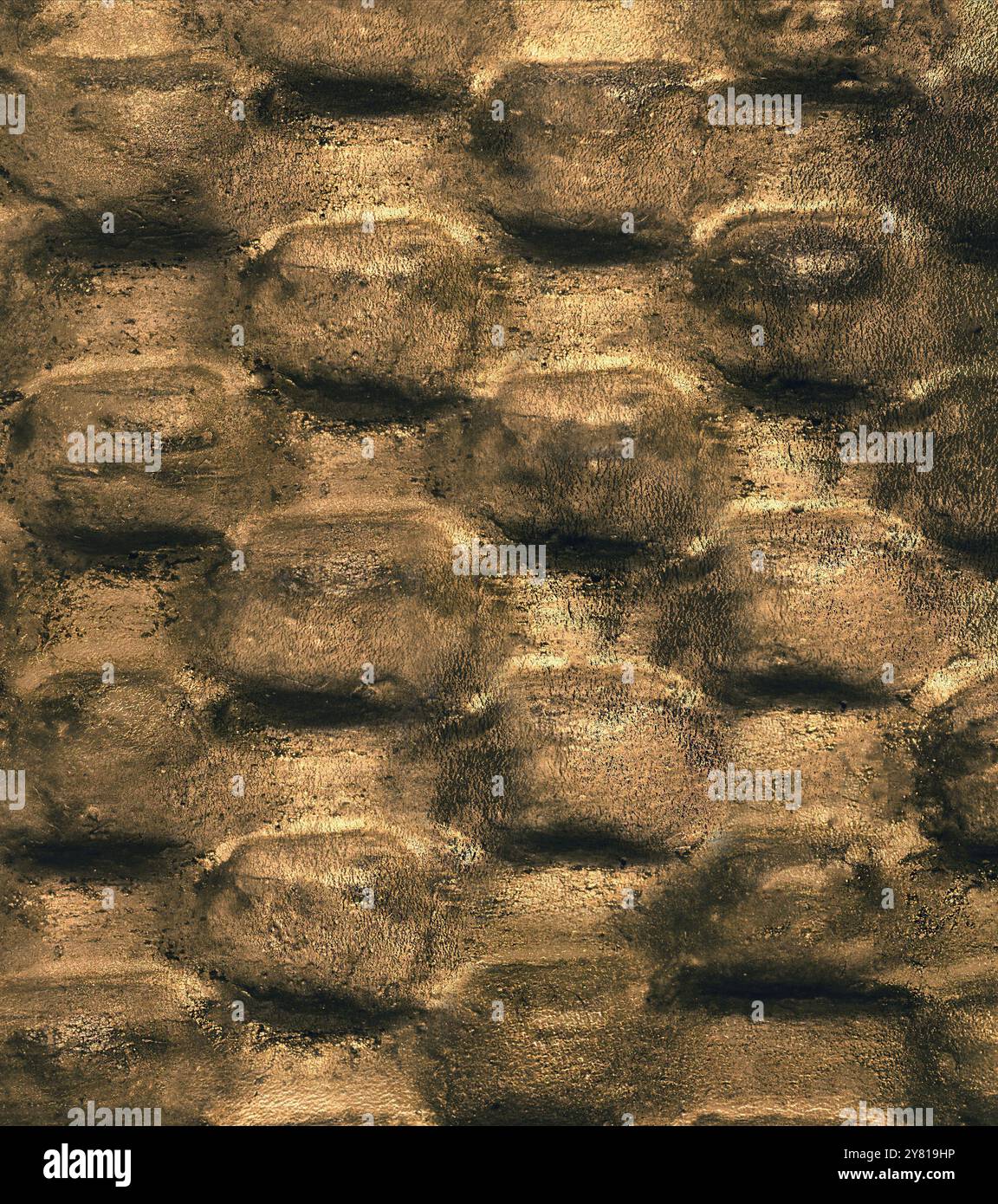 The metal surface is golden in color with oval dents on the surface ...