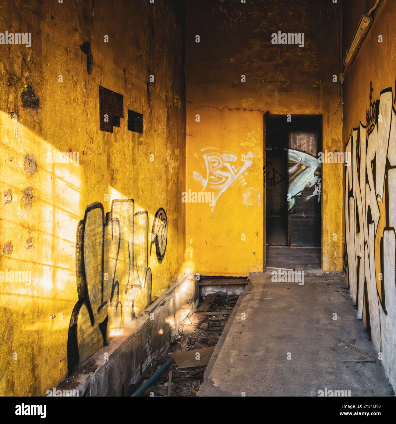Abandoned factory interior. Graffiti on yellow walls inside a neglected ... Abandoned factory interior. Graffiti on yellow walls inside a neglected ...