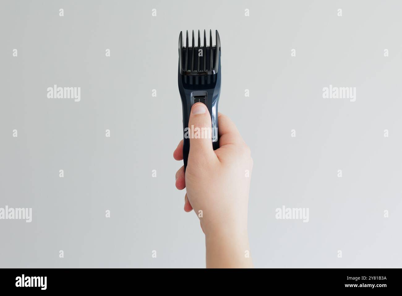 Man's hand holding electric hair cut machine on white background Stock ...
