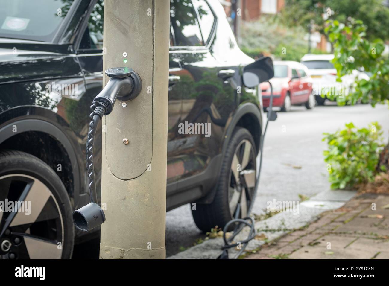 An electric car on-street charging on residential street Stock Photo ...