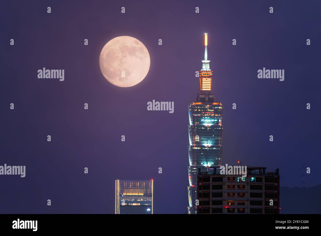 A golden autumn moon hangs over the Taipei skyline, casting a warm glow ...