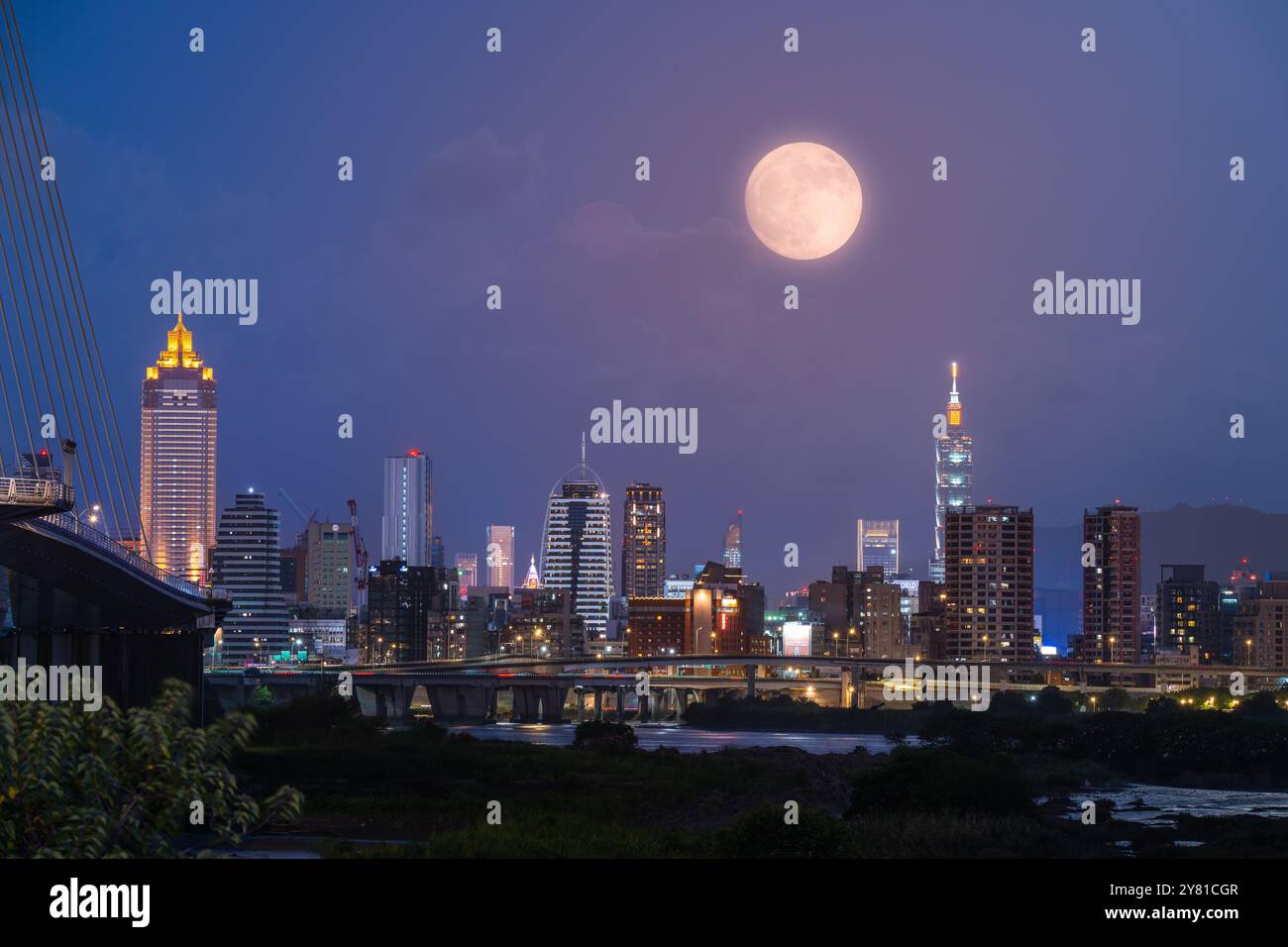 A golden autumn moon hangs over the Taipei skyline, casting a warm glow ...