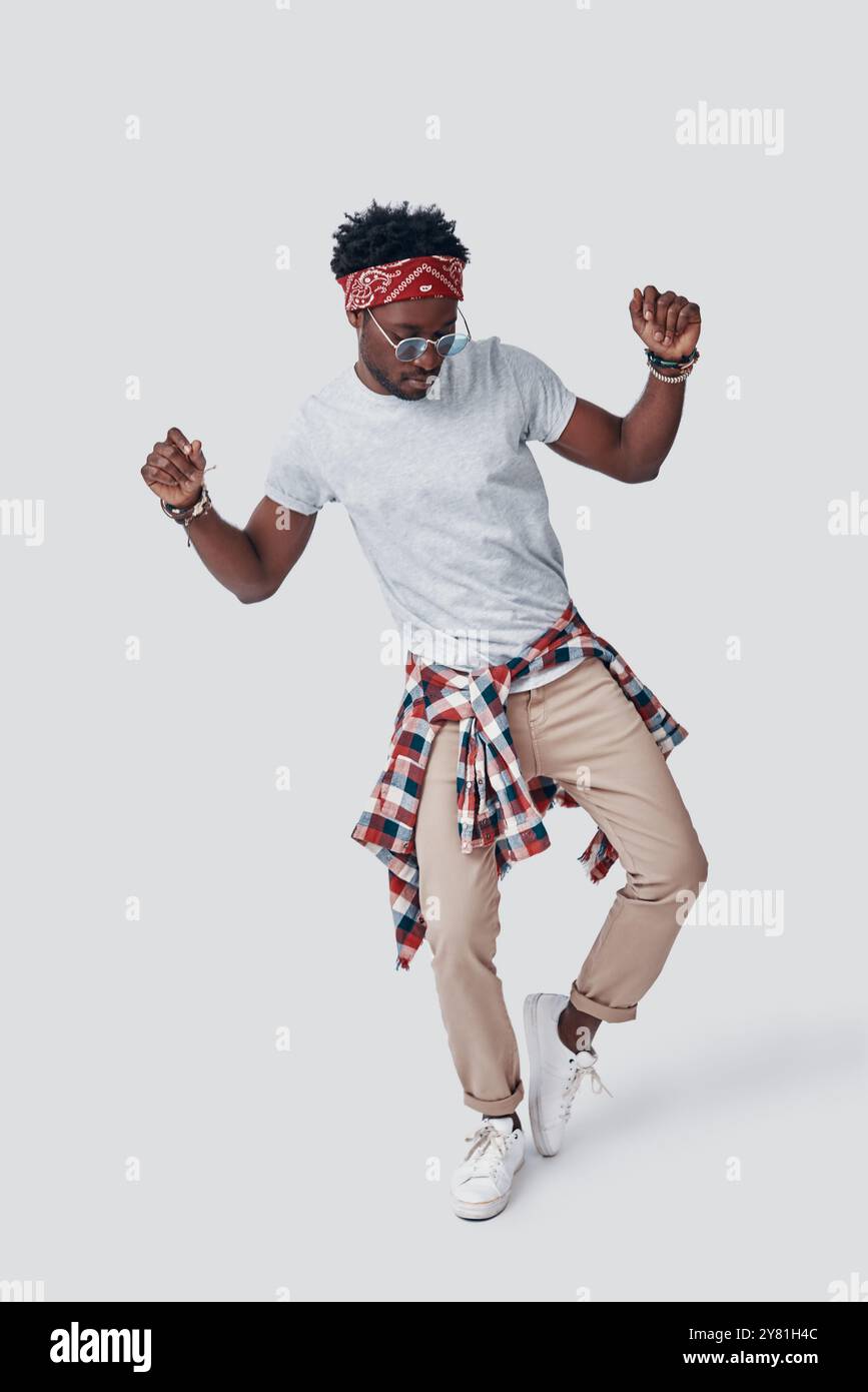 Full length of playful young African man dancing while standing against ...