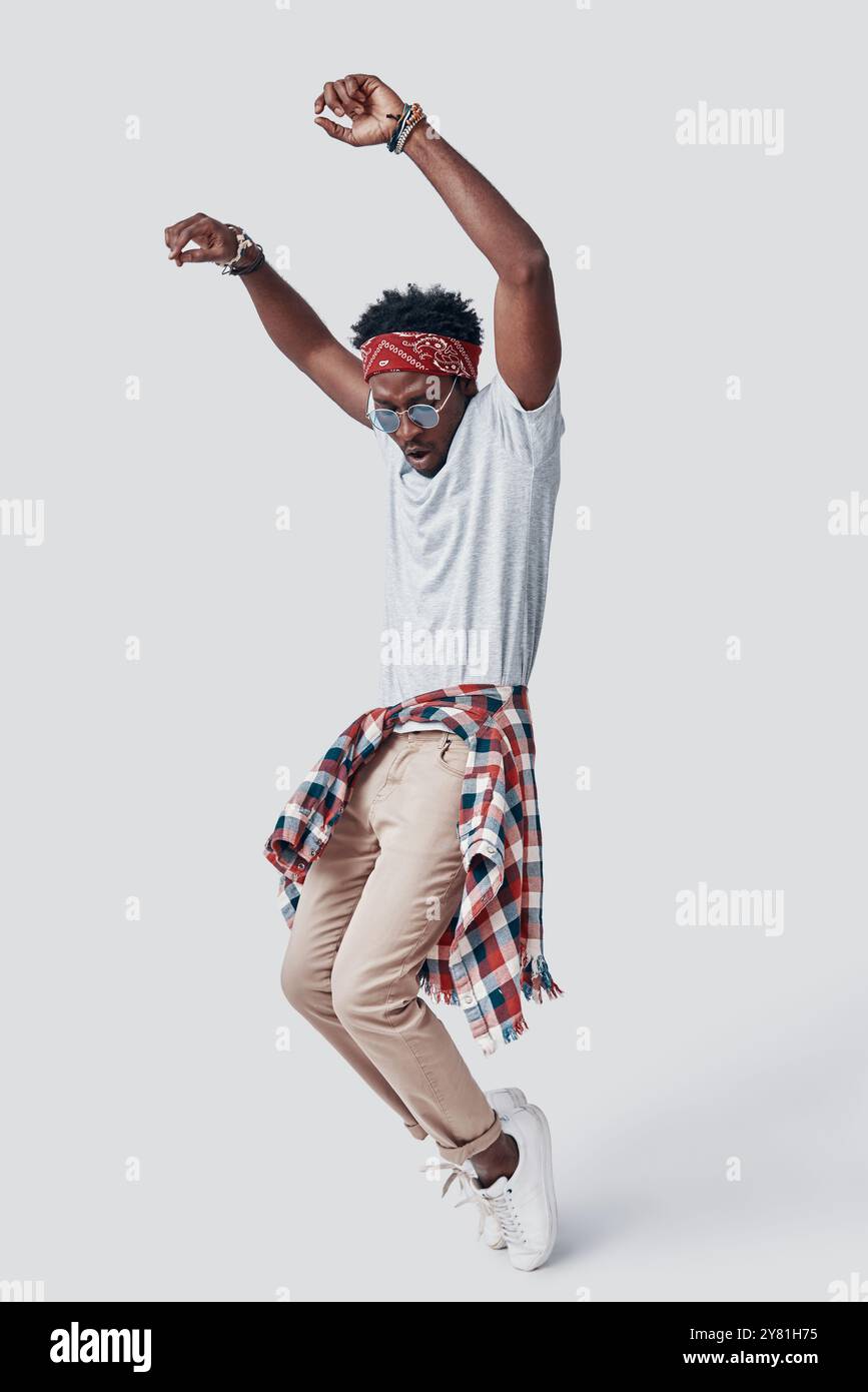 Full length of playful young African man dancing while standing against ...