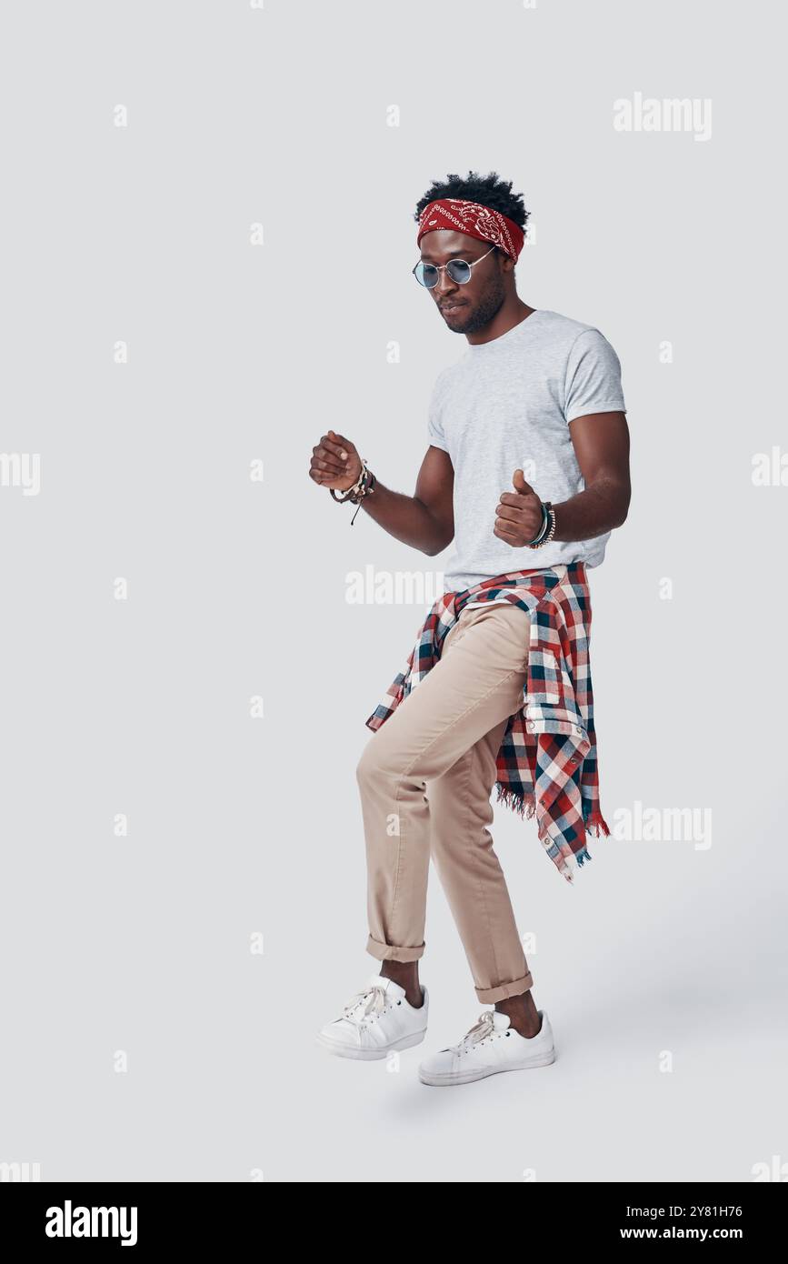 Full length of playful young African man dancing while standing against ...