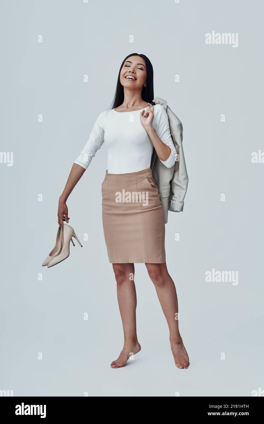 Time to relax. Full length of attractive young Asian woman smiling and ...