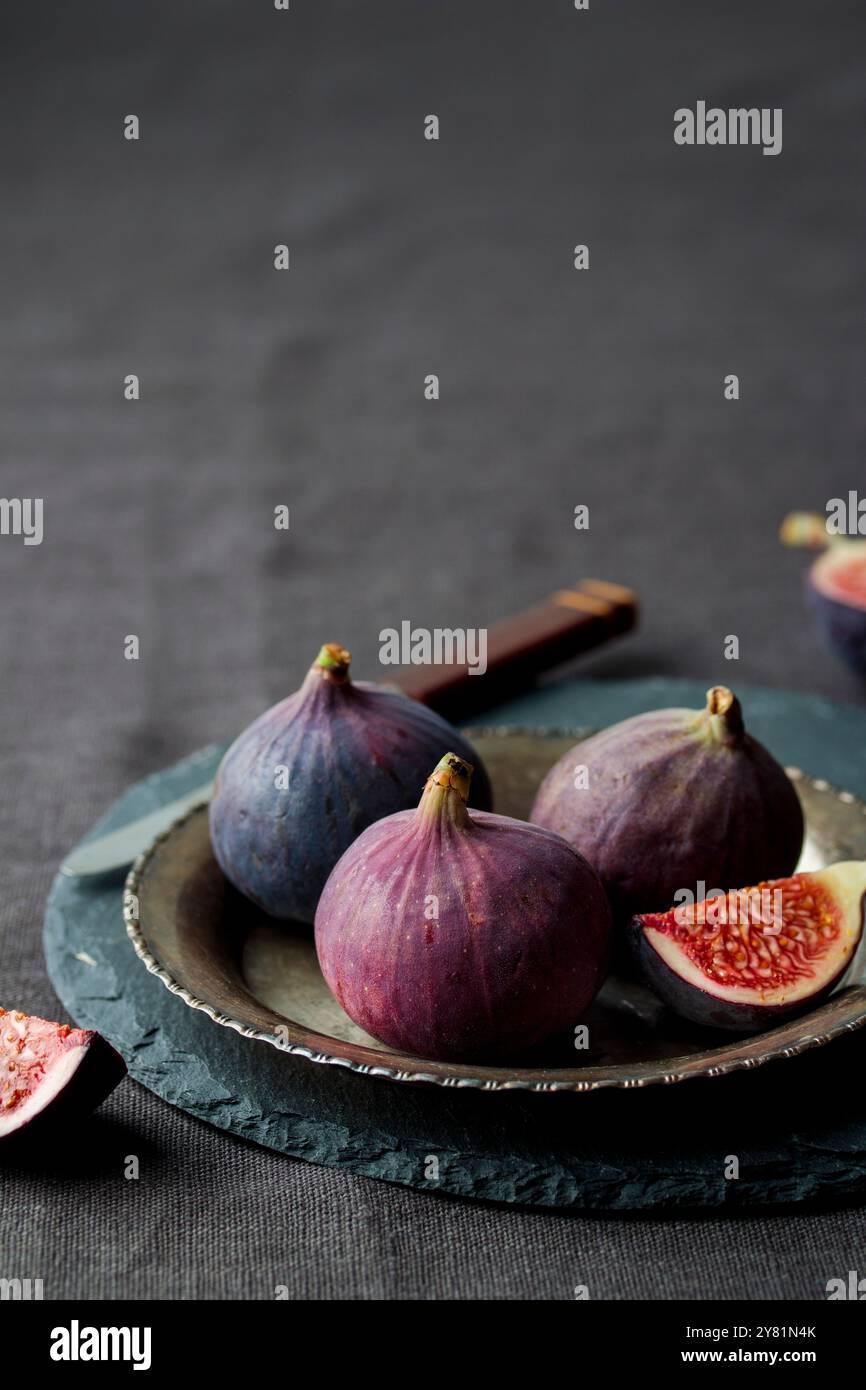 Fresh ripe and sweet whole and sliced figs with a kitchen knife on an ...