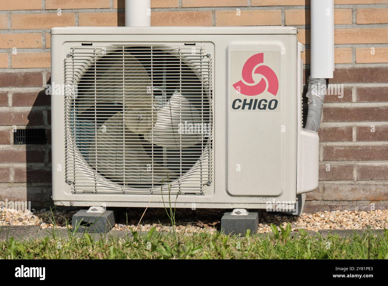 modern air-source heat pump unit mounted on the exterior wall of a ...