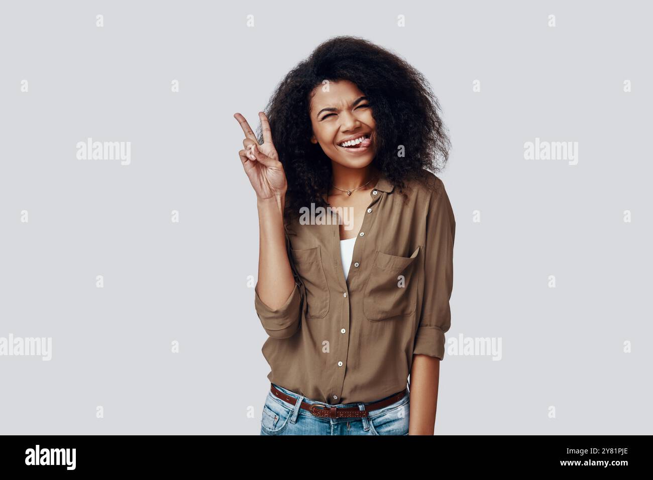 Playful young African woman smiling and sticking out tongue while ...