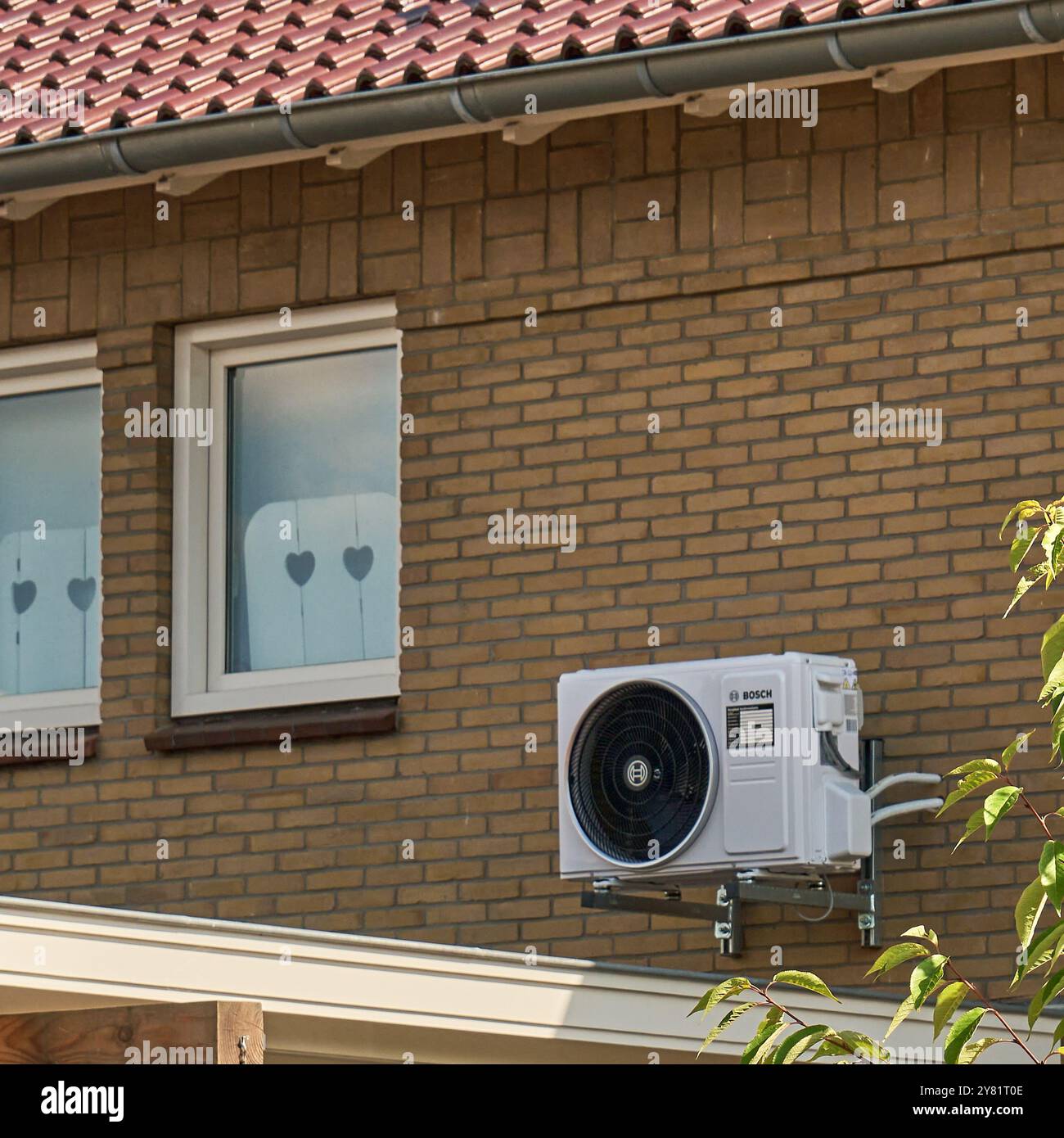 modern air-source heat pump unit mounted on the exterior wall of a ...