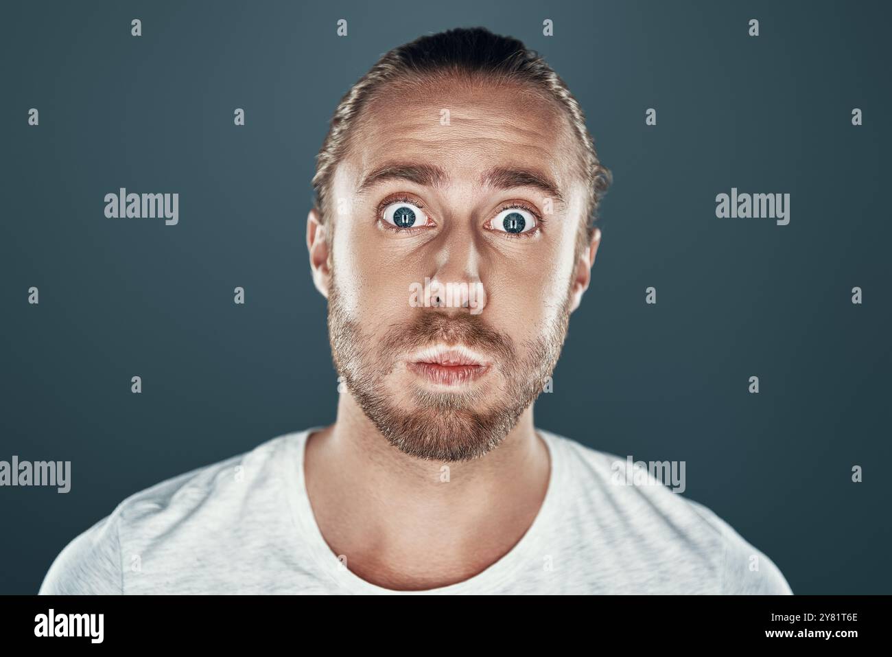 Real surprise. Shocked young man looking at camera and making a face ...