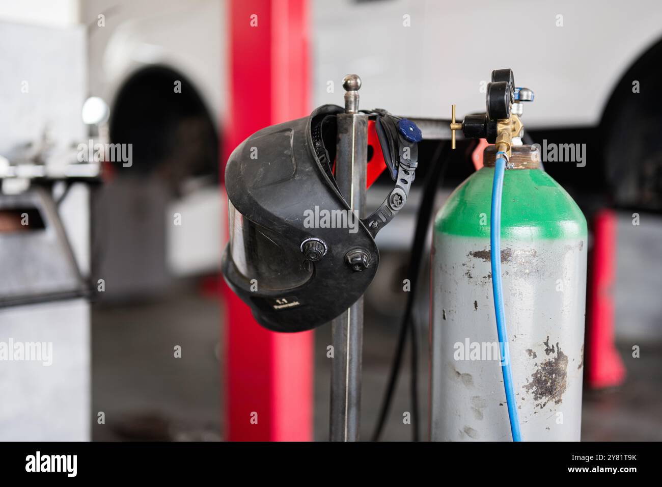 Close-up of a welding helmet and gas cylinder in an automotive workshop ...