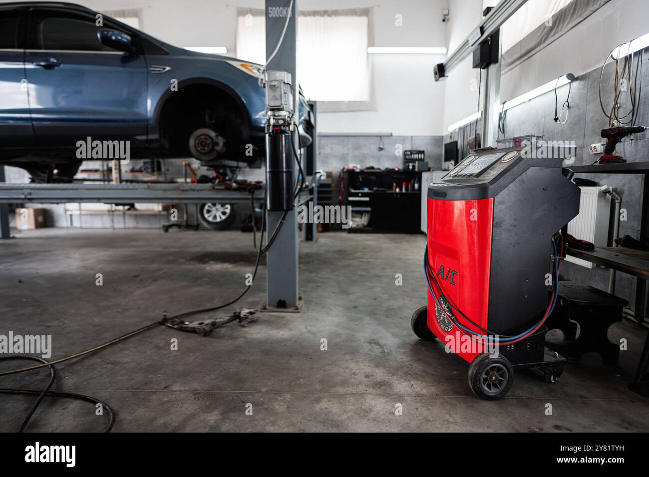 Image of a modern auto repair garage featuring a vehicle on a hydraulic ...