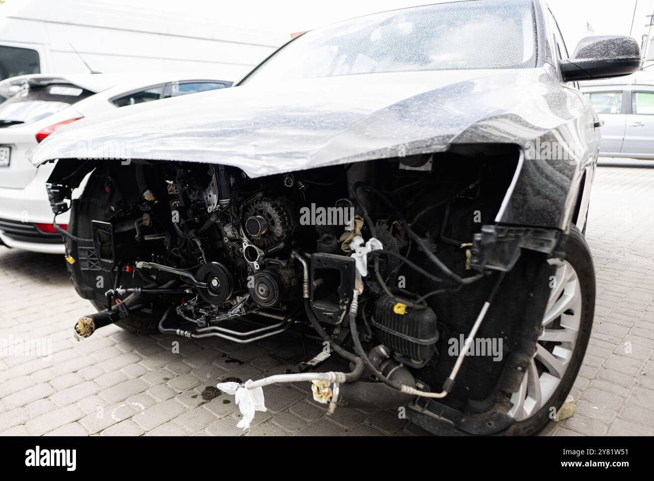 Close-up of a car with a damaged front bumper and exposed engine parts ...
