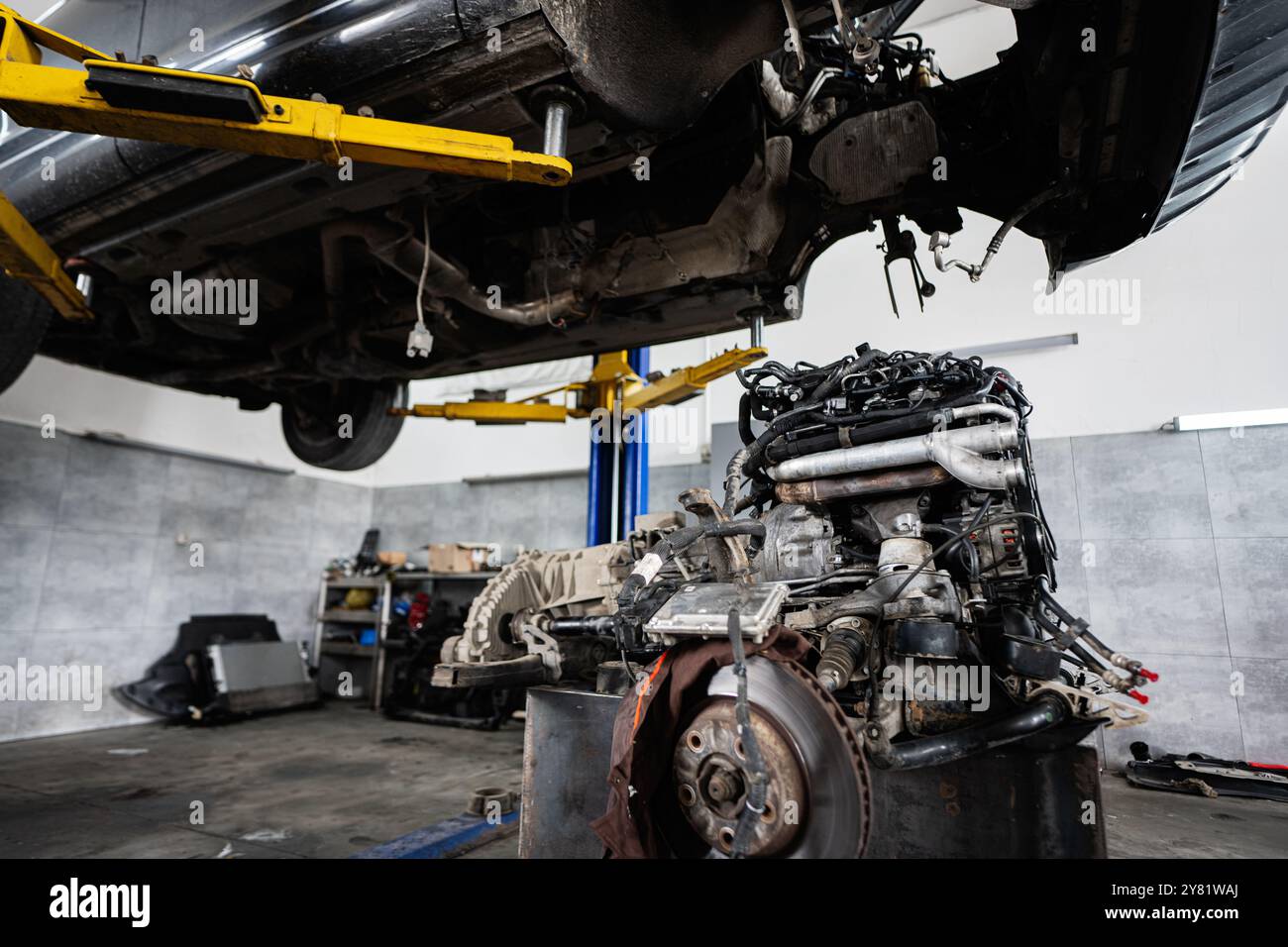 Detailed image of a car engine and undercarriage in an auto repair shop ...