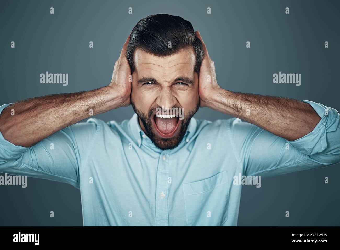 Negative emotion. Frustrated young man shouting and looking at camera ...