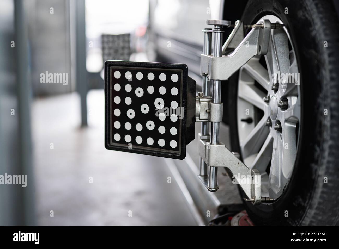 Close-up of a car wheel alignment process using advanced equipment in ...