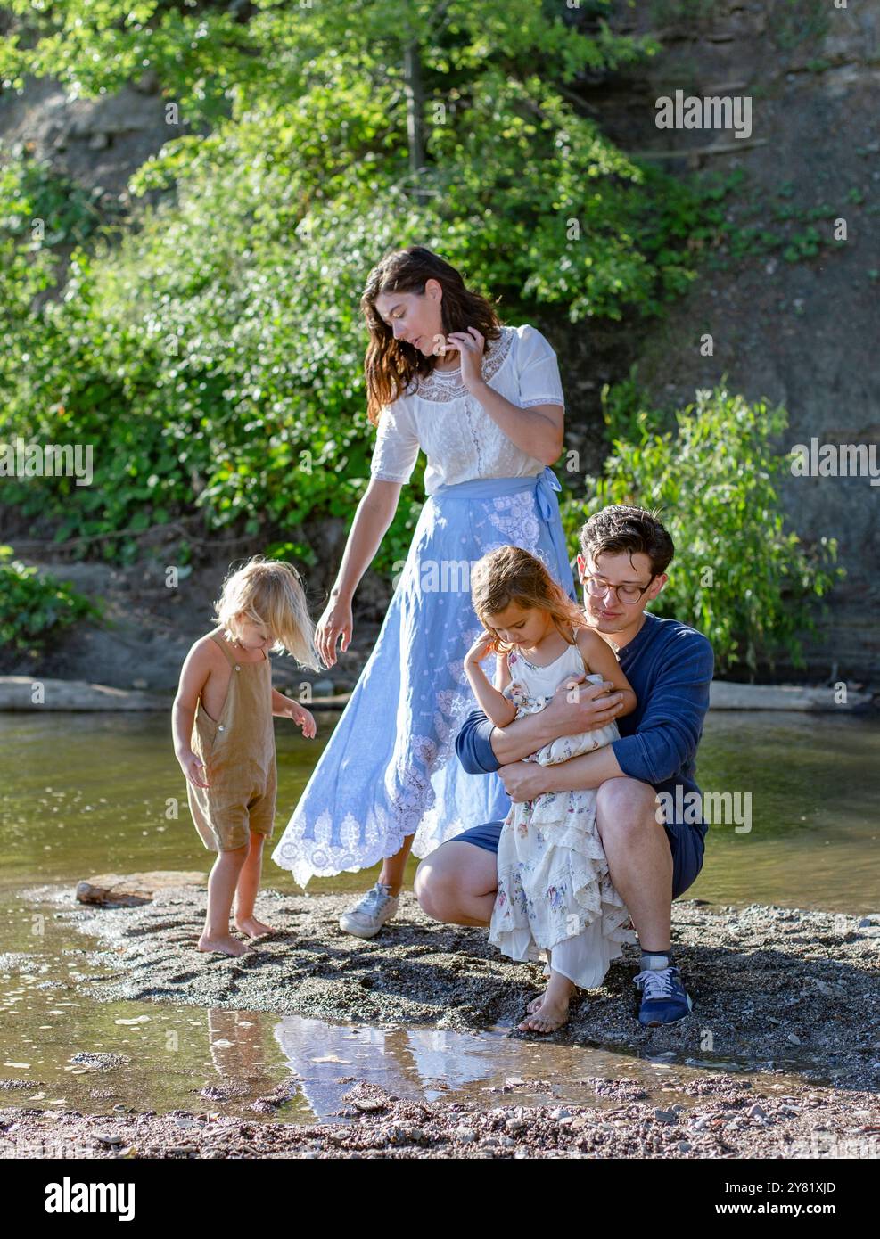 Family enjoying a day out by a water body with two young children and ...