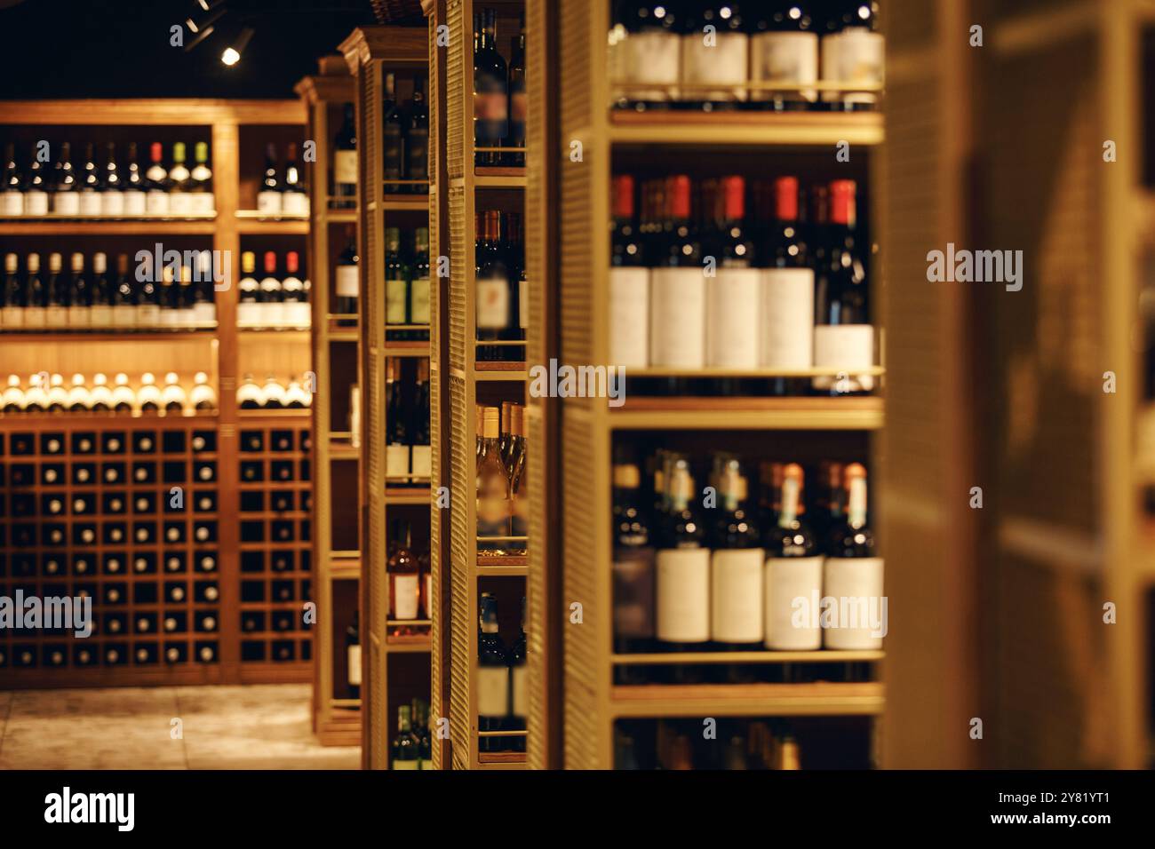 Wine cellar with shelves filled various positions of bottles. High wine ...