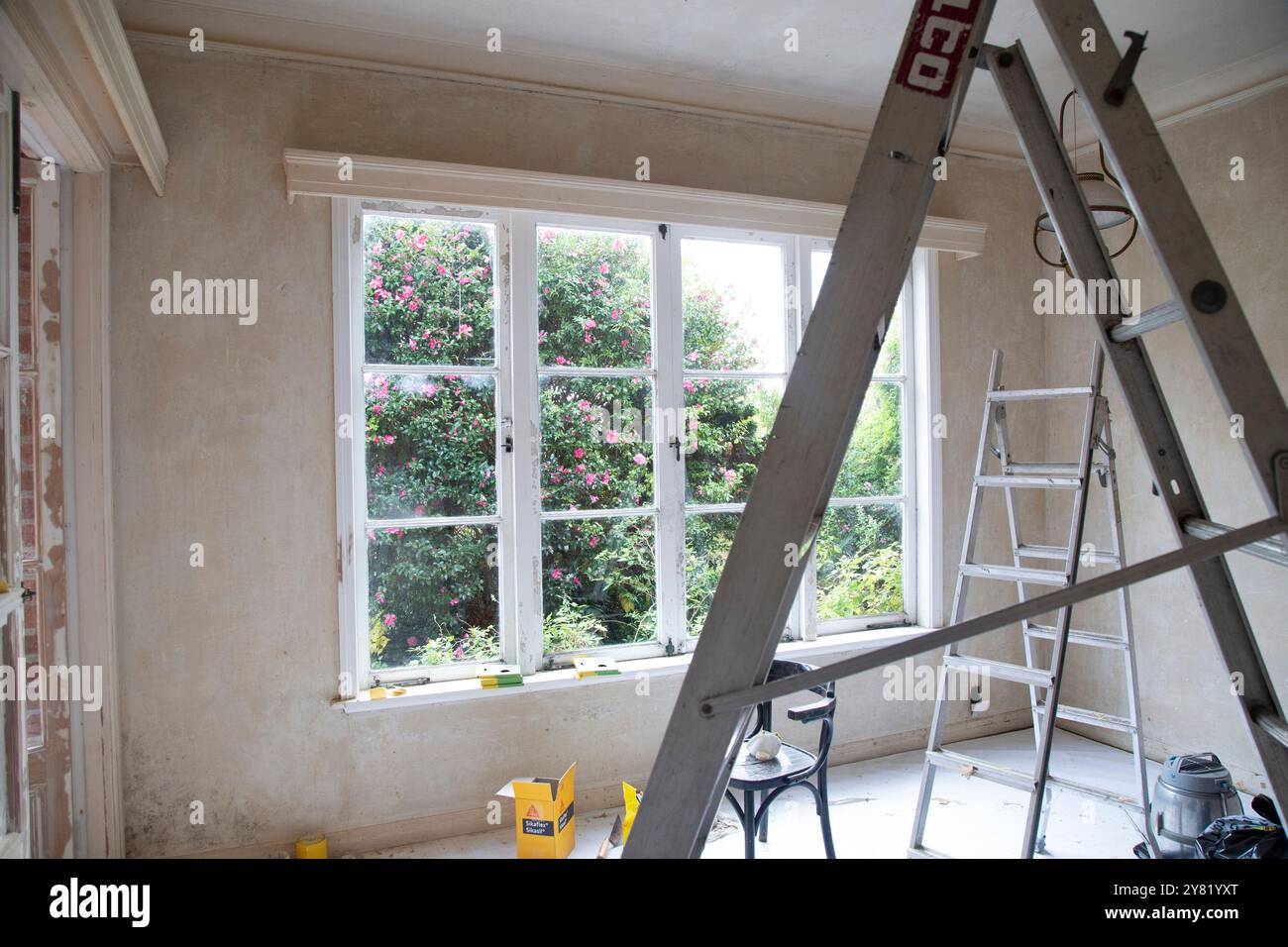 Renovation in progress inside a room with an open window overlooking a ...