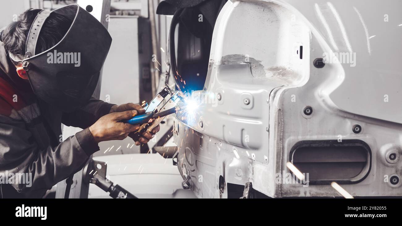 Worker welds car body with carbon dioxide welding. Weld of vehicle ...