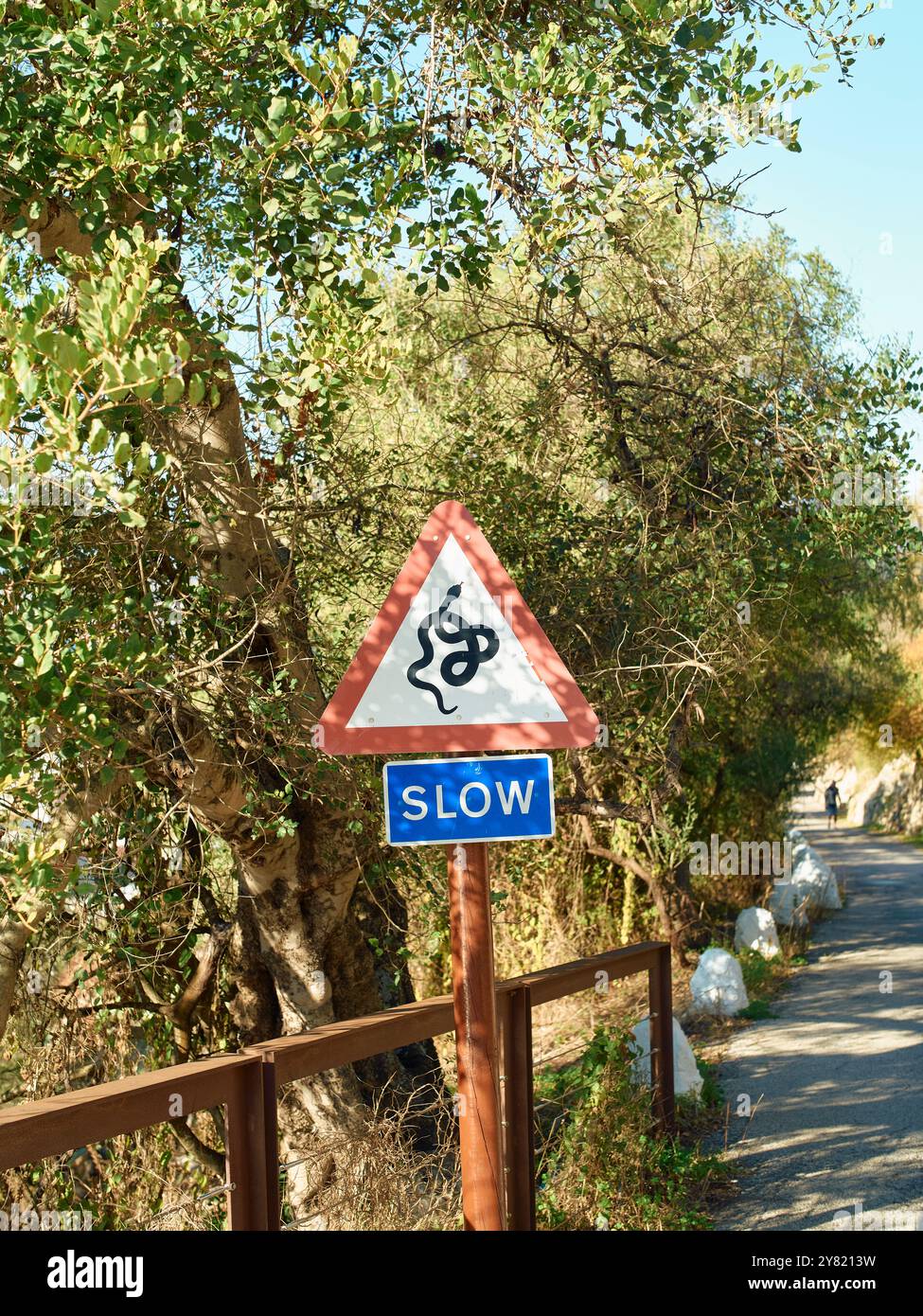 A red and white triangular slow sign featuring a snail symbol by a ...