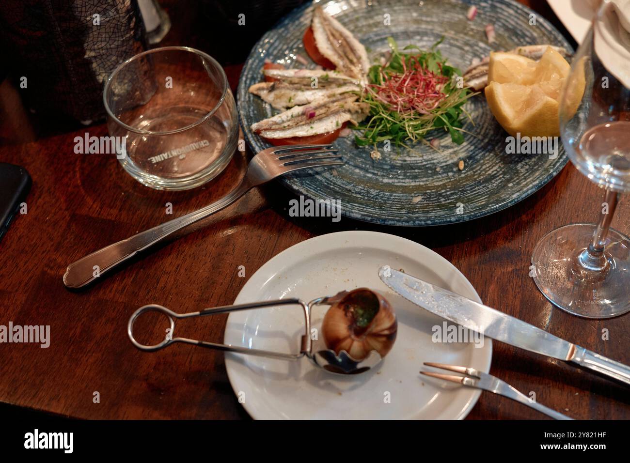 Half-eaten meal on a restaurant table with empty glasses and scattered ...