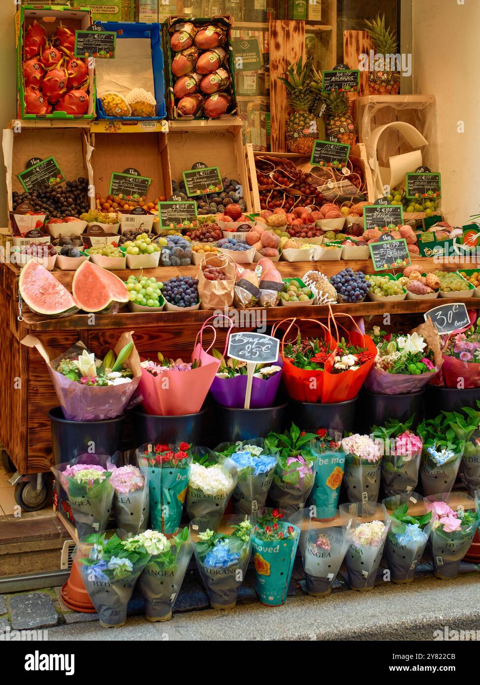 Fresh produce and flowers displayed outside a local grocery store Stock ...