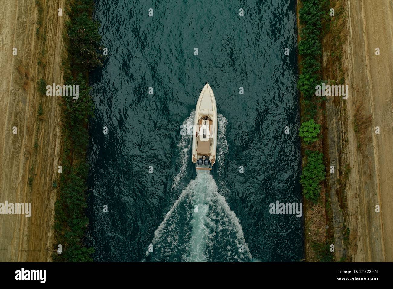 Aerial view of a white speedboat cruising through a narrow water ...
