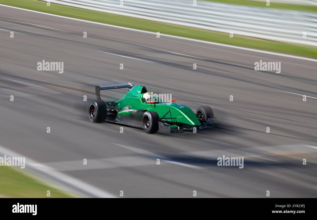 Race car F2 racing on speed track with motion blur at sunny summer day ...