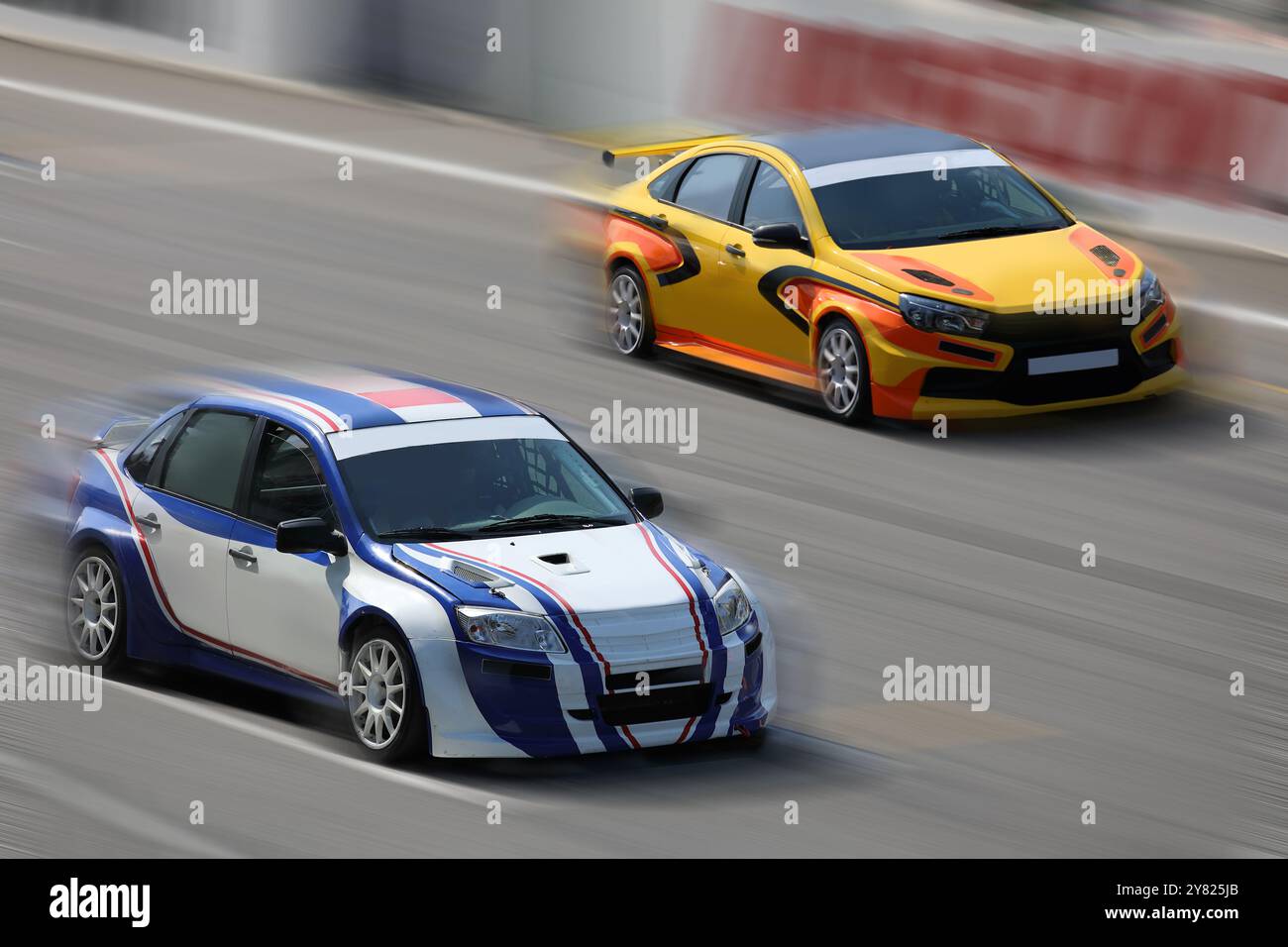 Two race cars racing at high speed on speed track with motion blur on a ...