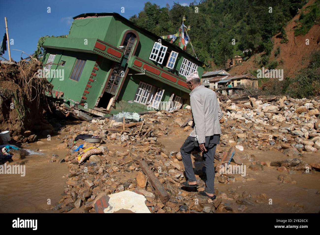 On October 1, 2024, in Kavre, Nepal. A man walk through rubbled house ...