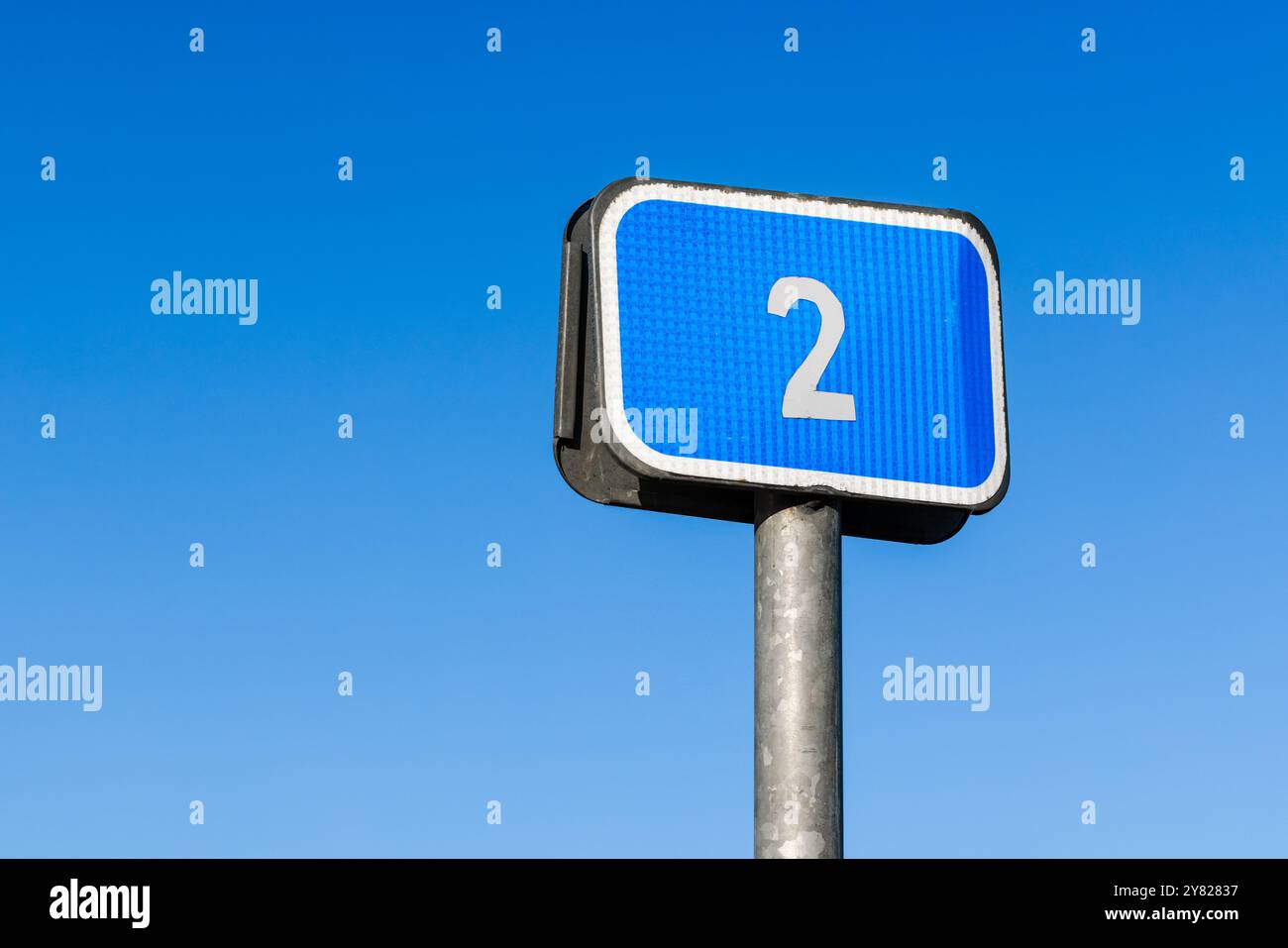 Blue road sign with 2 sign is under blue sky background, close up photo ...