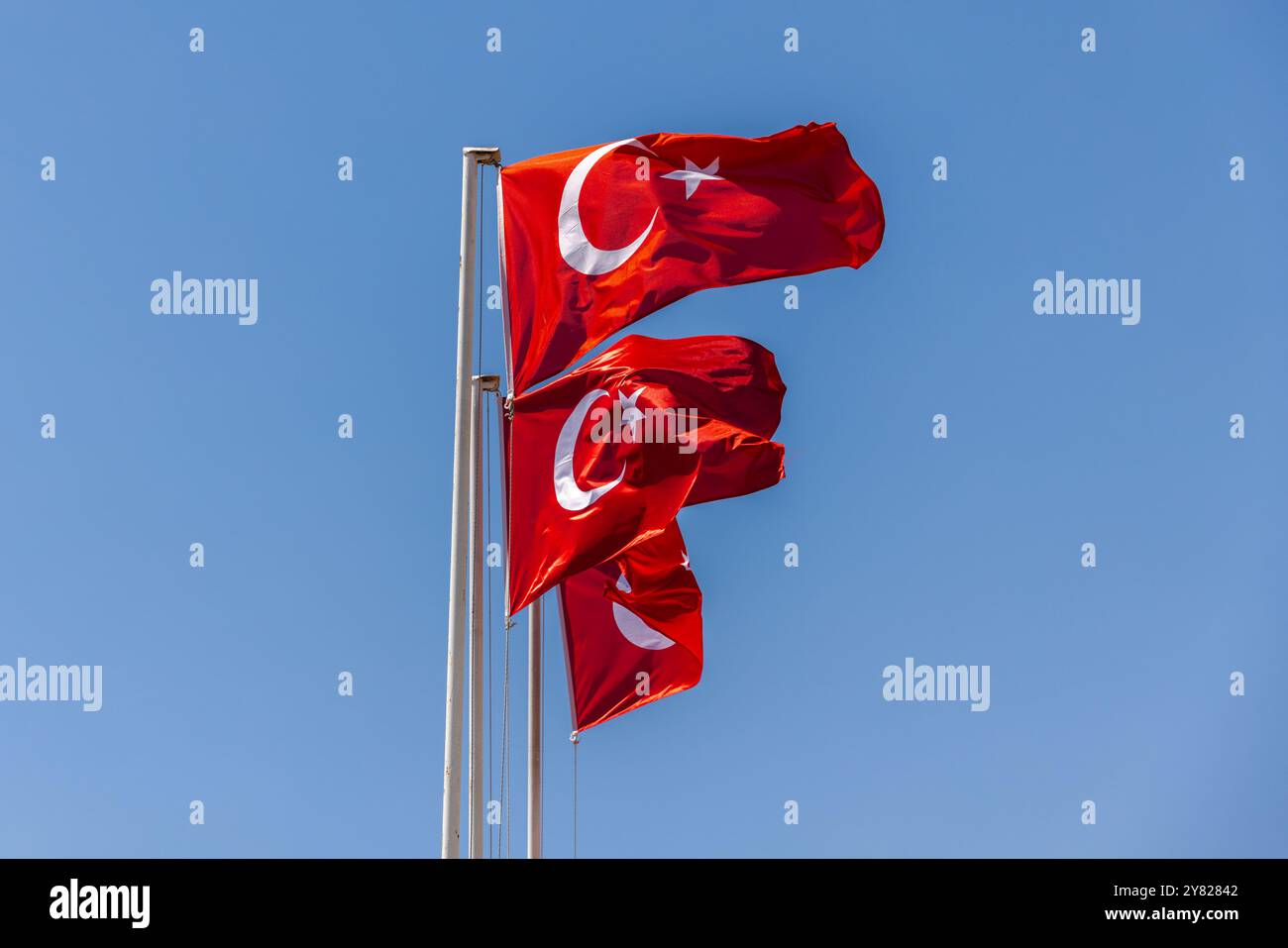 Flags of Turkey are under clear blue sky on a sunny day, close-up photo ...