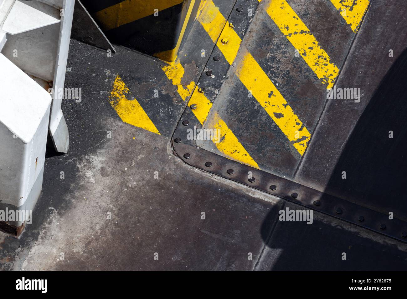 Black and yellow striped caution pattern painted over grungy steel ...