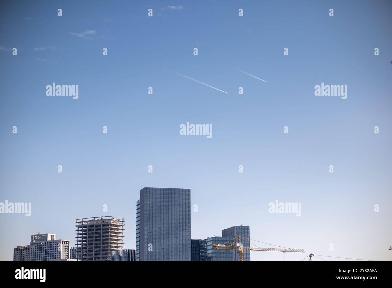 Two airplanes flying side by side in the blue sky, above the city Stock ...