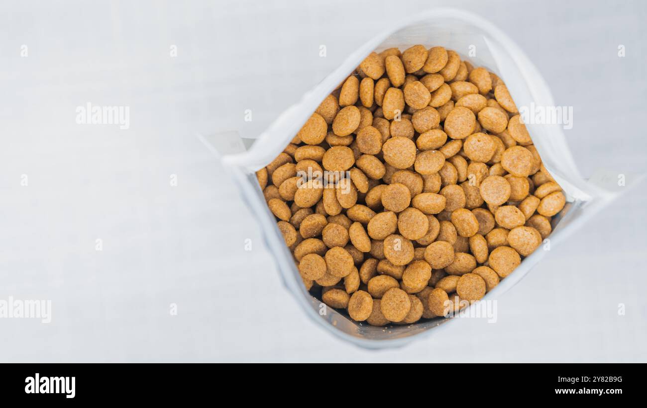 A top view of a transparent bag filled with small, round, brown pet ...