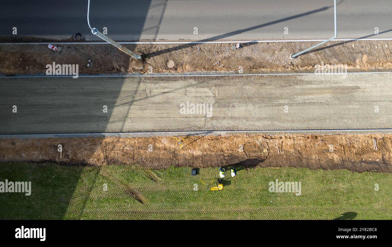 Aerial view of a sidewalk under construction with workers and equipment ...