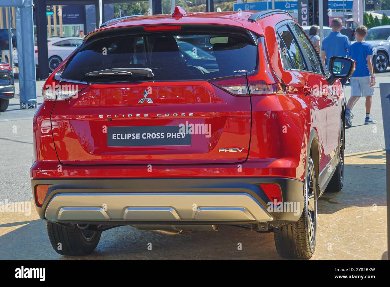 Mitsubishi eclipse cross phev showing its rear with visitors passing by ...