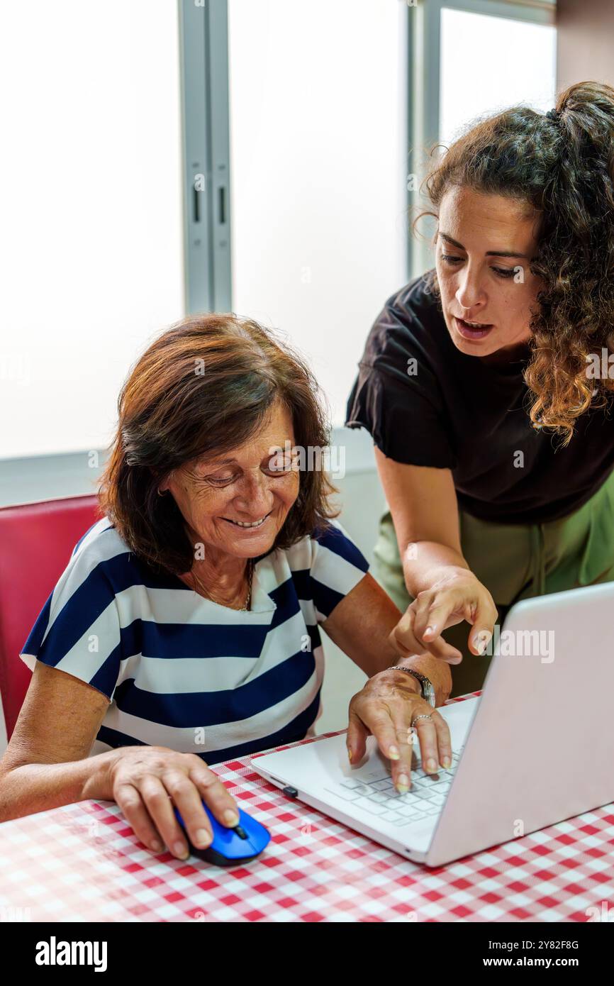 Middle-Aged Daughter Teaching Elderly Mother to Use a Laptop, Bridging ...