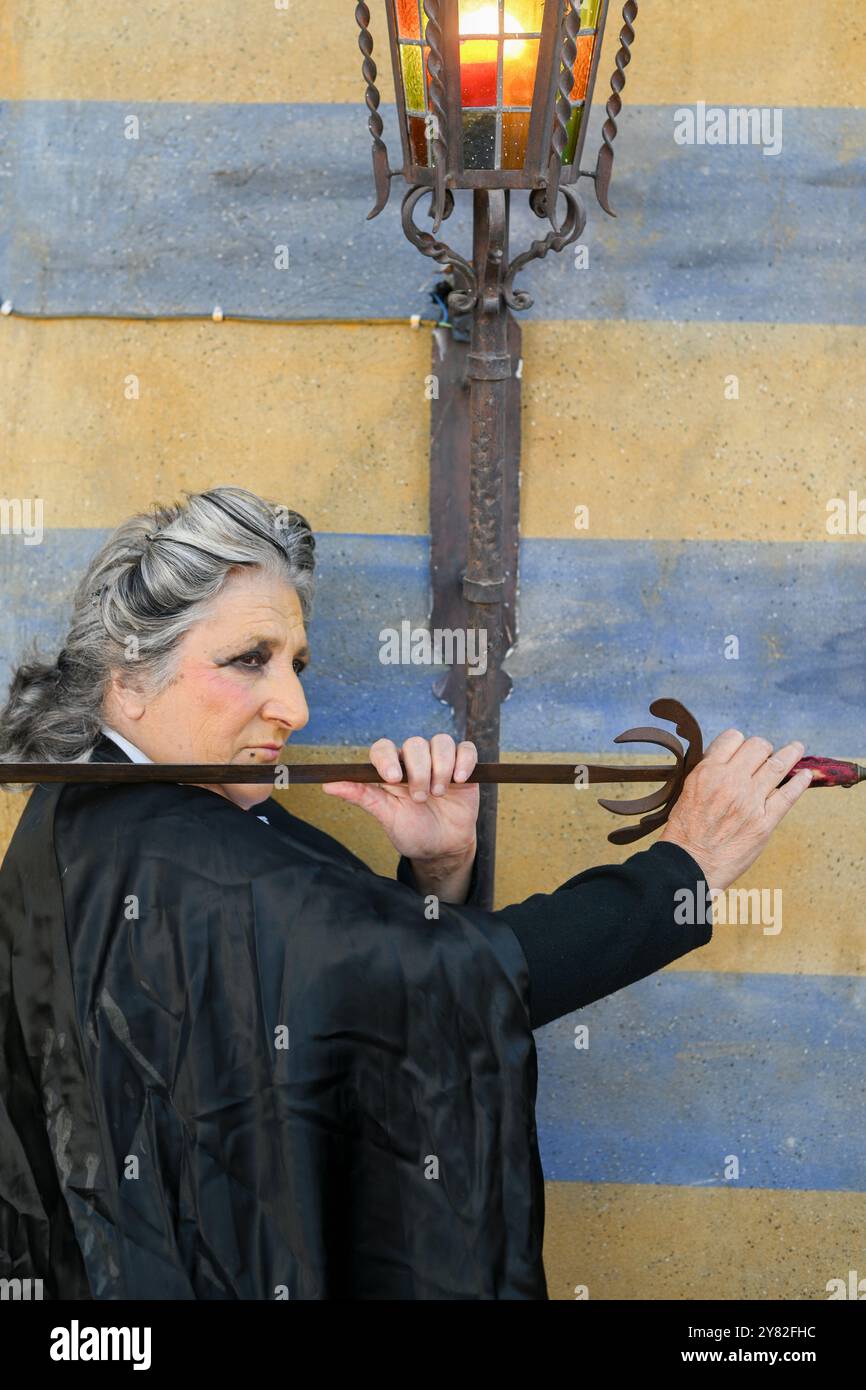 Fierce warlord poses under a street lamp, holding a sword and wearing a ...